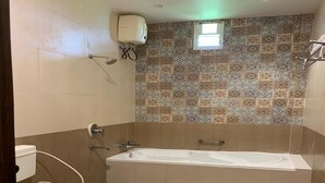 Um banheiro com banheira, vaso sanitário e chuveiro.