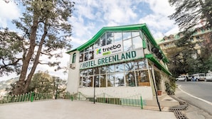 Um hotel chamado "Hotel Greenland" com telhado verde e janelas amplas.