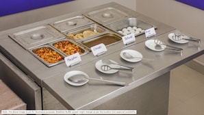Buffet com seções de comida identificadas, incluindo Macaroni, Chow e ovos cozidos.