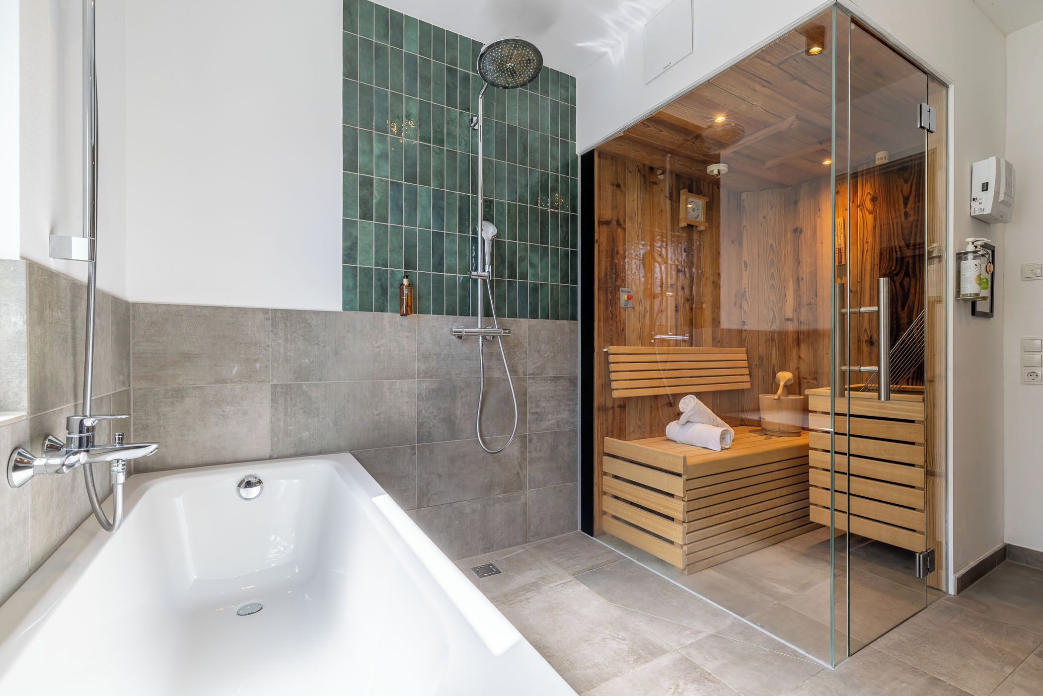 Um banheiro moderno com banheira, chuveiro e sauna de madeira.