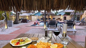 Uma mesa de jantar com uma refeição, um copo de vinho tinto e um cardápio.