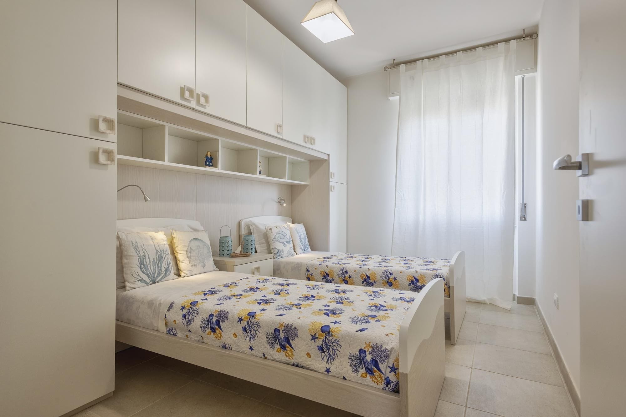Quarto com duas camas, um guarda-roupa e um banheiro.