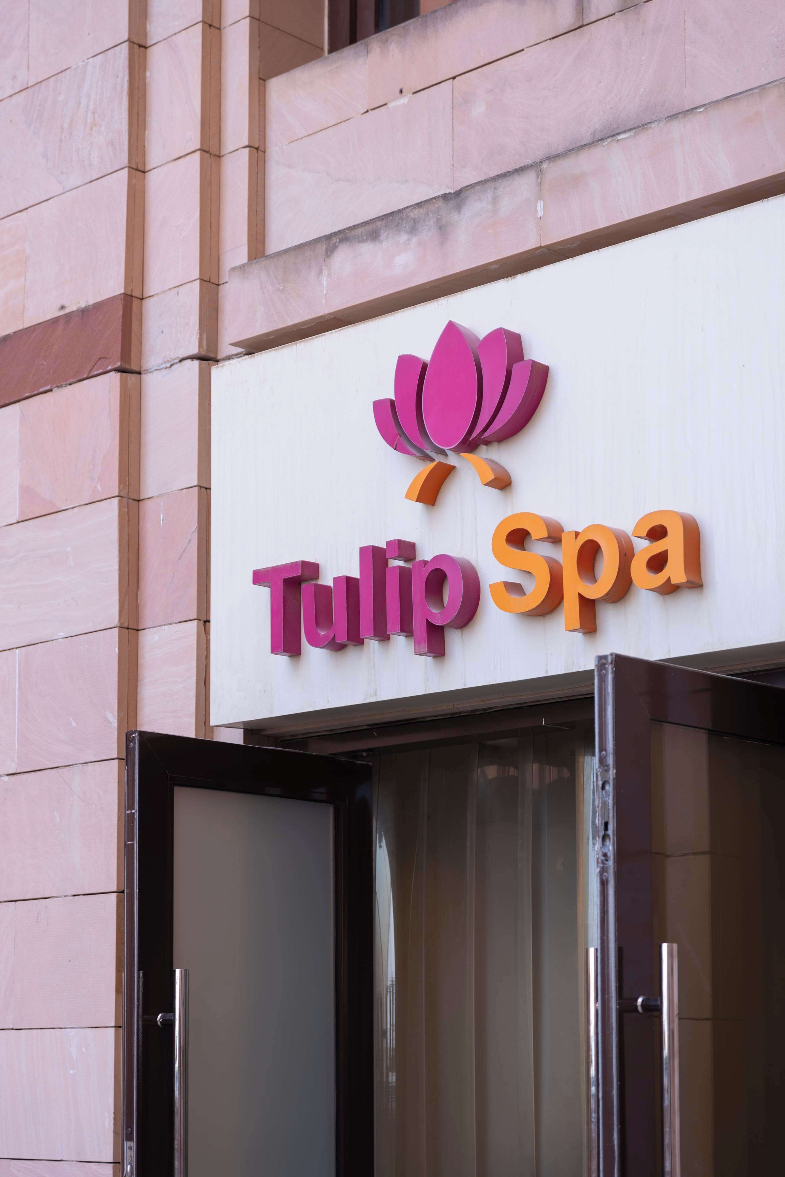 Placa com o nome 'Tulip Spa' e logotipo de uma flor de lótus.