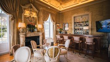 Uma área de bar com lareira, assentos e uma variedade de garrafas.