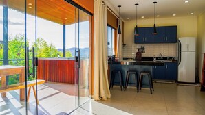 Cozinha moderna com vista, com uma ilha grande, banquetas e armários azuis.