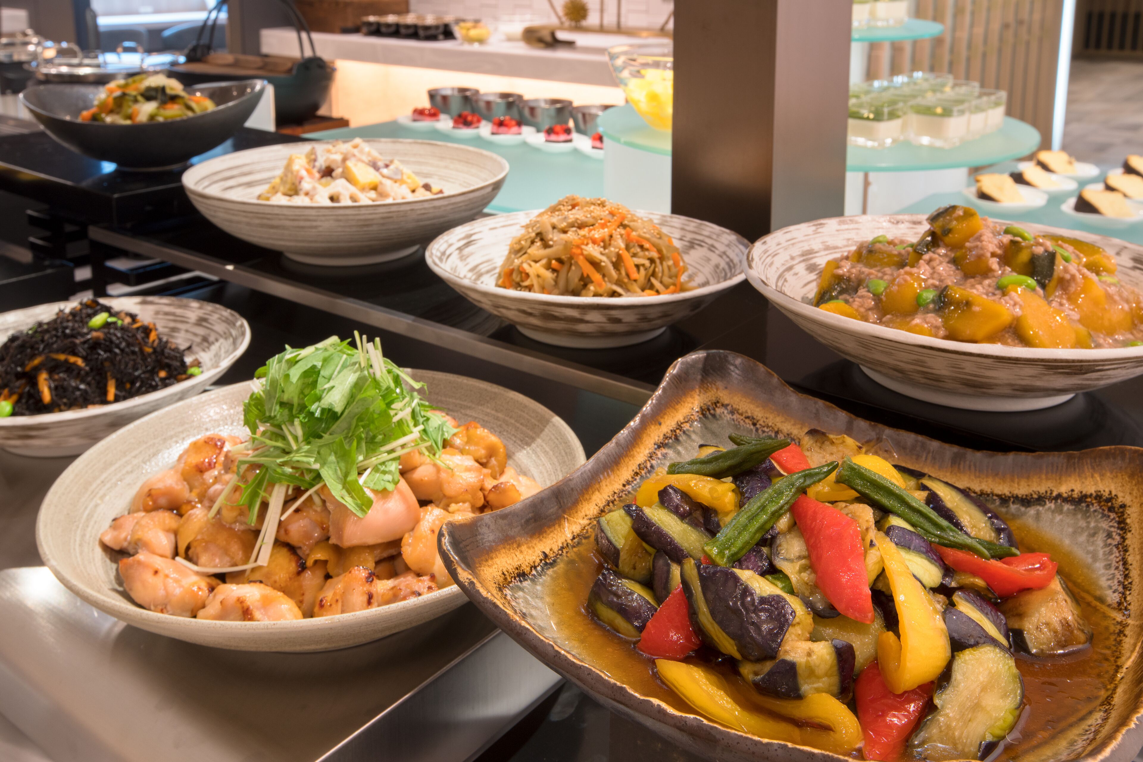 Buffet com diversos pratos, incluindo frutos do mar, vegetais e macarrão.