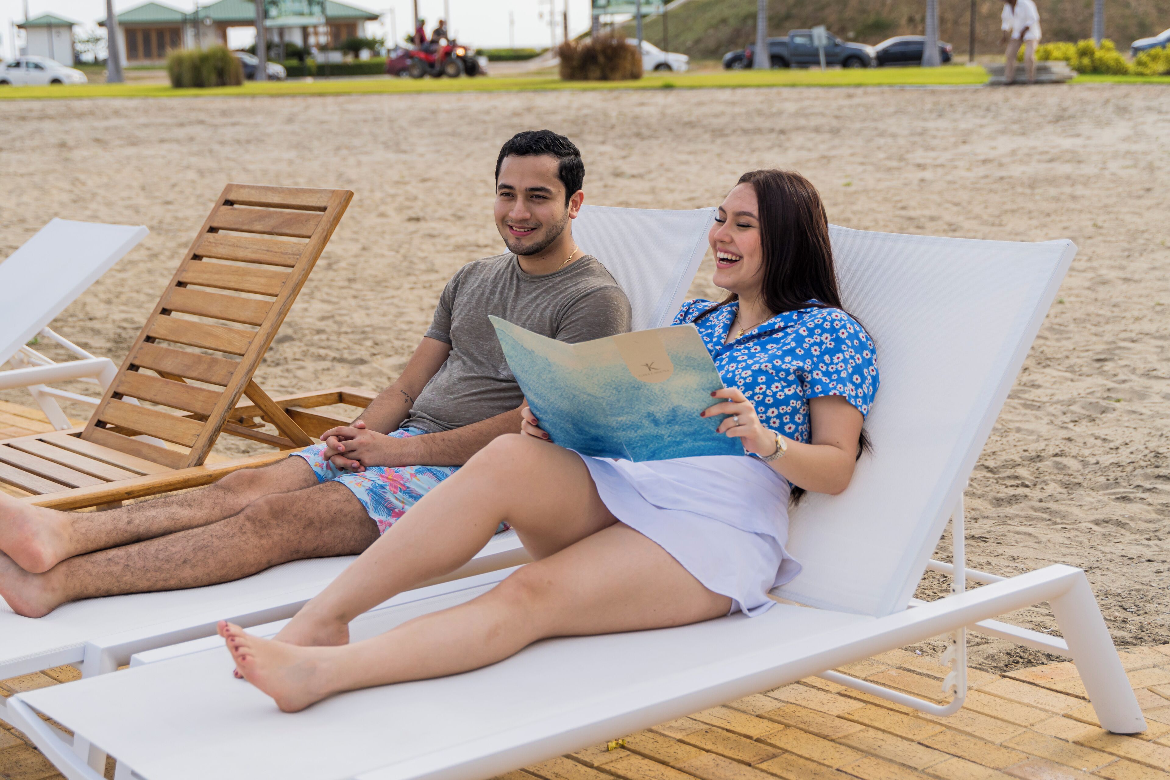Duas pessoas sentadas em cadeiras de praia sobre um deck de madeira.