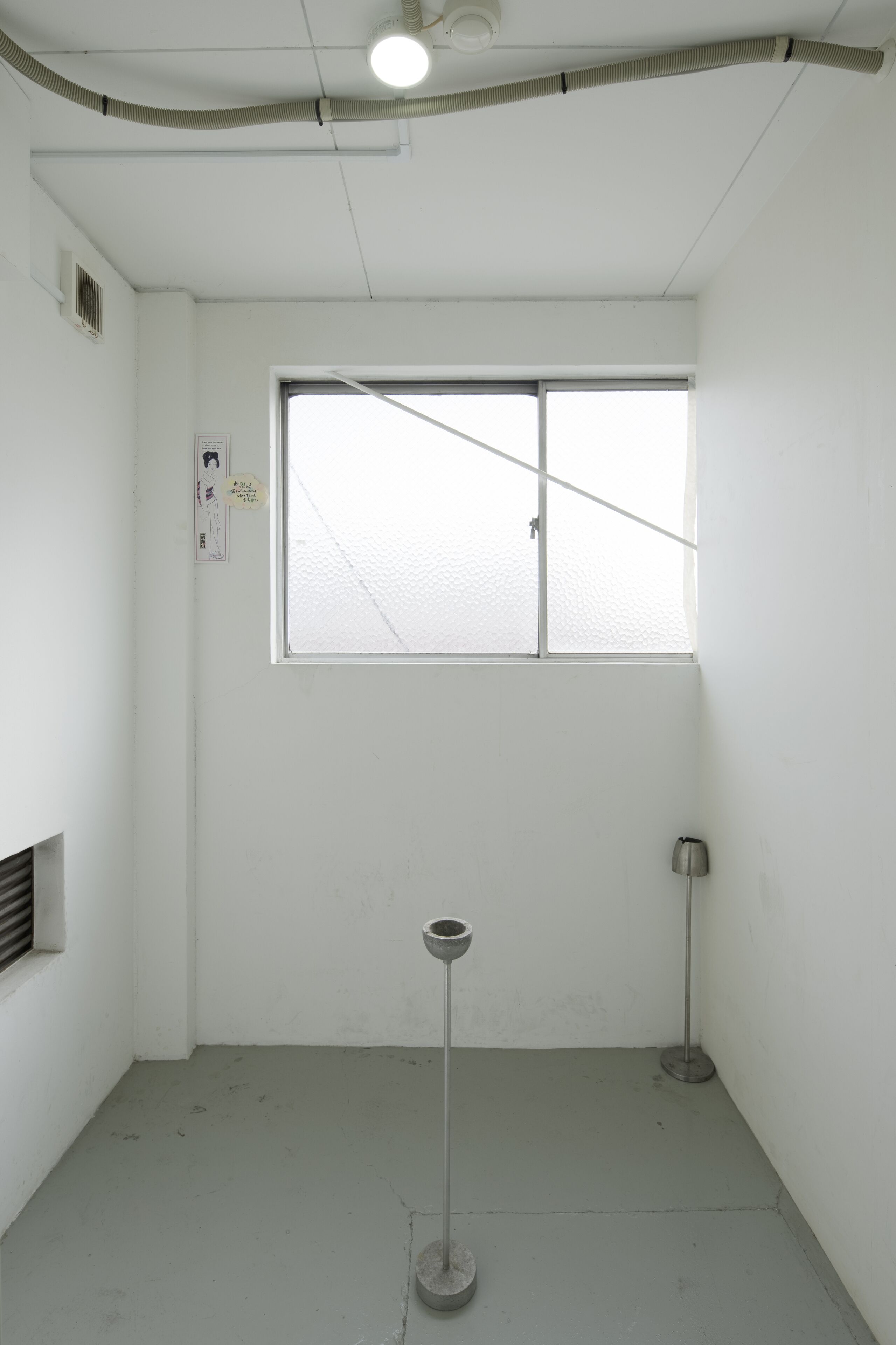 Quarto com uma janela grande, um abajur e um radiador.