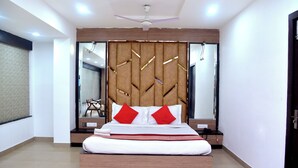 Um quarto moderno com uma cama grande, um ventilador de teto e um espelho sobre a cama.