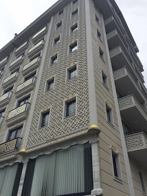 Um edifício alto com fachada geométrica marcante e varandas.