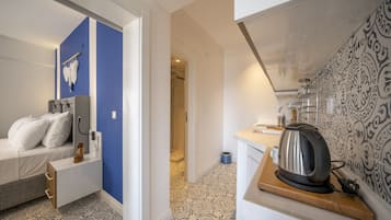 Minifrigorífico, uma placa de cozinha, utensílios de cozinha