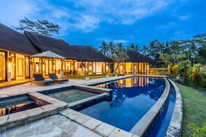 Um resort moderno com piscina, espreguiçadeiras e um jardim bem cuidado.