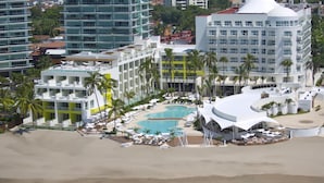 Resort com piscina central, vários edifícios e zona de praia.