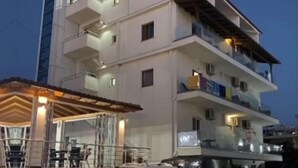 Um hotel com vários andares, varandas e área externa coberta.