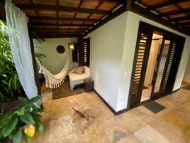 Um quarto com rede, cama e um cão.