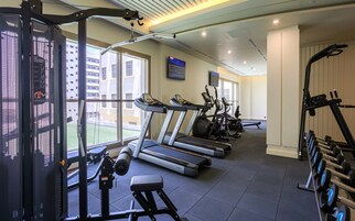 Academia com esteiras, máquinas de musculação e halteres.