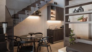 Um interior moderno com escada, área de refeições, cozinha e estantes.