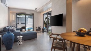 Uma sala de estar moderna com um sofá, uma mesa de jantar e uma TV.