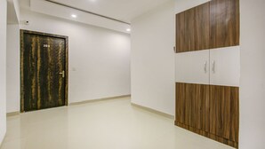 Corredor com uma porta identificada como '203', um armário de madeira e um chão ladrilhado.