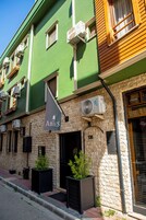 Um edifício com fachada verde, um letreiro com a inscrição "ABIES" e aparelhos de ar condicionado instalados na área externa.