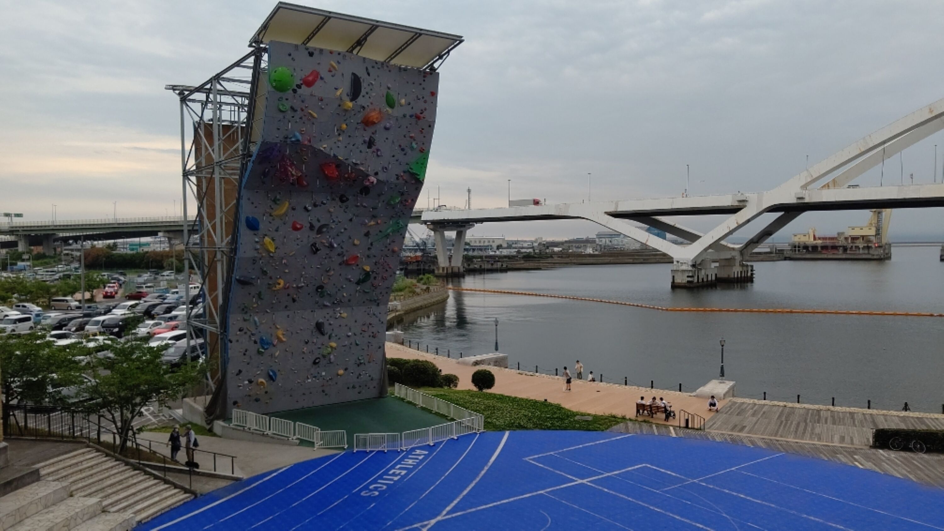 Uma parede de escalada com uma pista de corrida azul à frente.