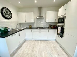 Um frigorífico, um micro-ondas, um forno, uma placa de cozinha 