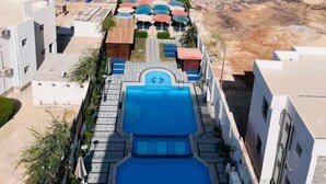 Um resort com piscina, praia e vista para o oceano.