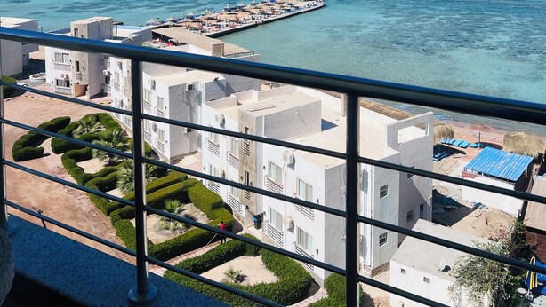 Hotel à beira-mar com vista para o mar, um cais e um jardim bem cuidado.