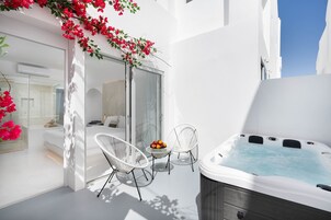 Uma área externa moderna com hidromassagem, cadeiras de vime branco e porta de vidro que dá para um quarto.