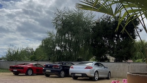 Uma área de estacionamento com vários carros e uma fileira de plantas floridas.