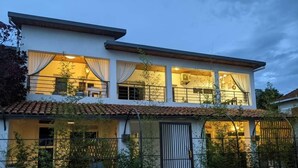 Um edifício de dois andares com telhado telhado, grandes janelas e entrada com portão.