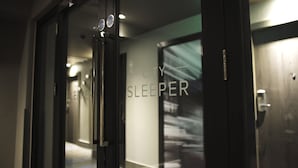 Um corredor com portas identificadas como 'CITY SLEEPER'.