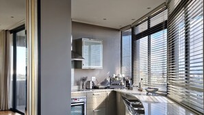 Cozinha moderna com uma janela grande, forno embutido e pia de aço inoxidável.