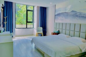 Quarto de hotel com cama, cadeira, escrivaninha e janela com cortinas.