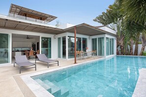 Uma casa moderna com piscina, área de refeições e cozinha.