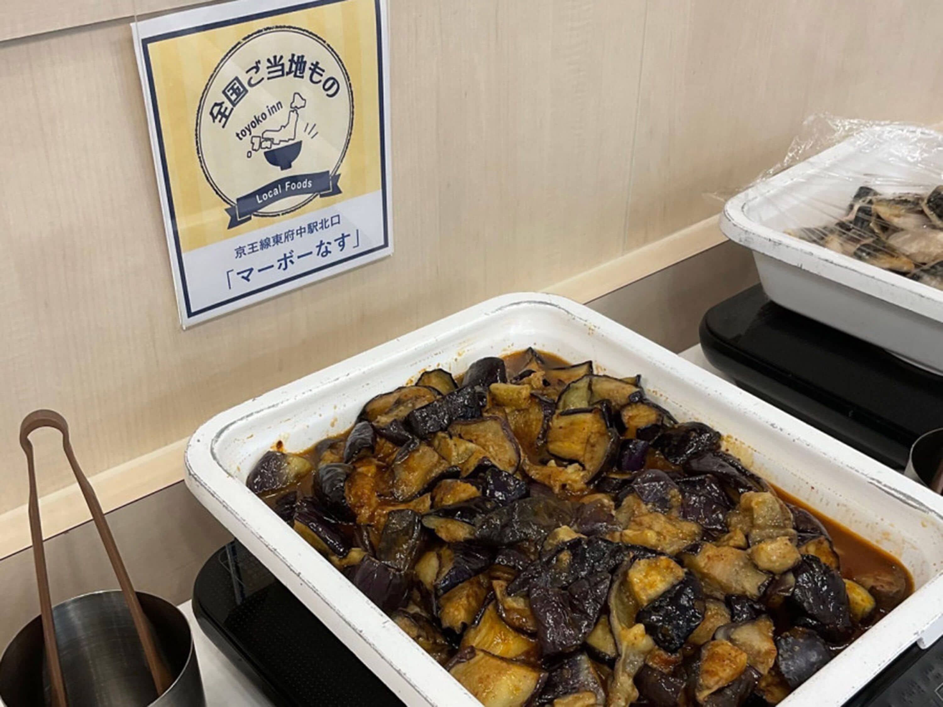 Uma área de buffet com uma travessa de berinjela cozida.