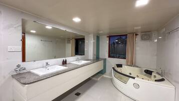 Uma casa de banho moderna com duas pias, um espelho grande, uma banheira e uma janela com cortinas.