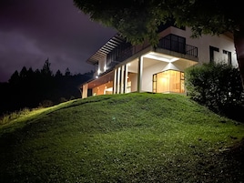 Uma casa moderna com varanda, janelas amplas e um gramado bem cuidado.