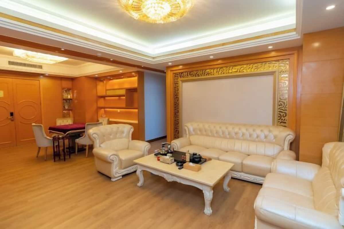 Uma sala de estar espaçosa com um amplo sofá, uma mesa de centro e um espaço de jantar com cadeiras e mesa.