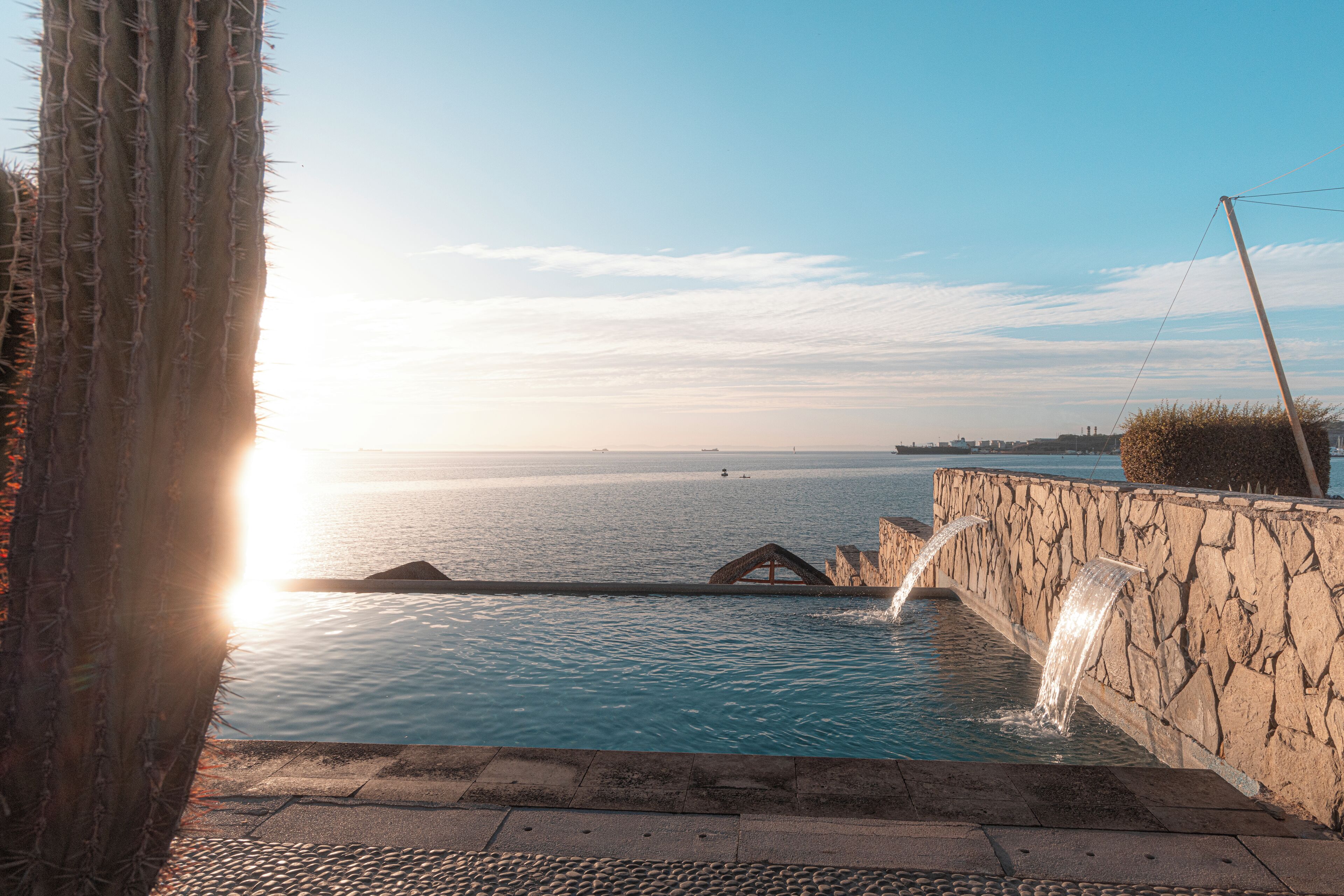 Piscina com muro de pedra e cachoeira.