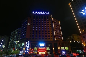 Edifício de vários andares com sinalização iluminada e janelas, provavelmente um hotel ou propriedade comercial.