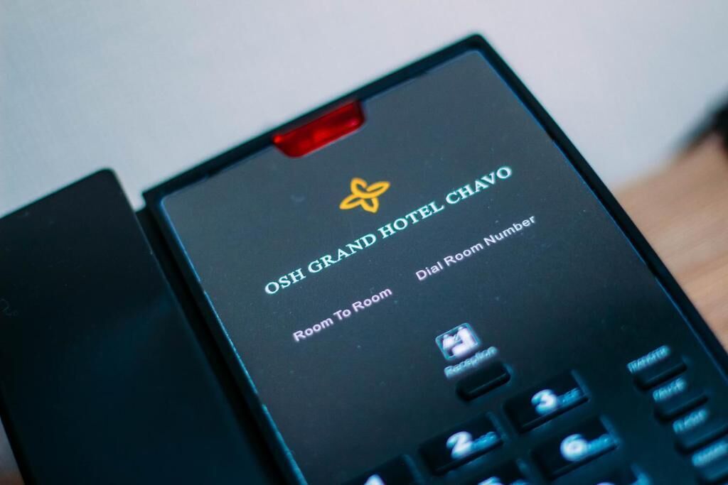 Painel de controle de quarto de hotel com o nome 'OSH GRAND HOTEL CHAVO' e opções para 'Quarto a Quarto' e 'Discar Número do Quarto'.