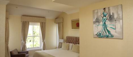 Quarto com uma cama grande, uma cadeira, uma janela com cortinas e um quadro na parede.