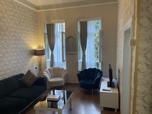 Suíte luxo, 2 quartos, quartos conectados | Área de estar | TV LED 32 polegadas com canais via satélite, TV, serviços de streaming