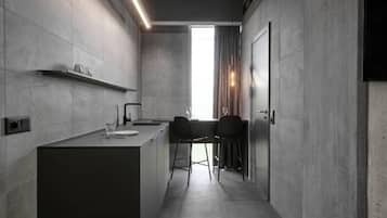 Uma cozinha moderna com uma ilha central, banquetas e uma estante embutida.