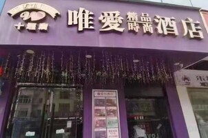 Um hotel com fachada roxa e uma placa com caracteres chineses.