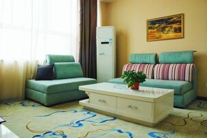 Uma sala de estar com um sofá, uma mesa de centro com uma planta e um quadro na parede.