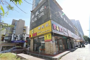 Um edifício com vários estabelecimentos comerciais no andar térreo, incluindo um spa e um restaurante.