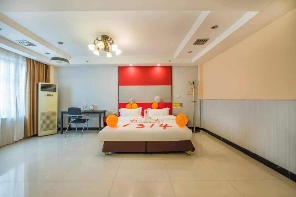 Quarto de hotel com uma cama grande, uma escrivaninha e uma cadeira.