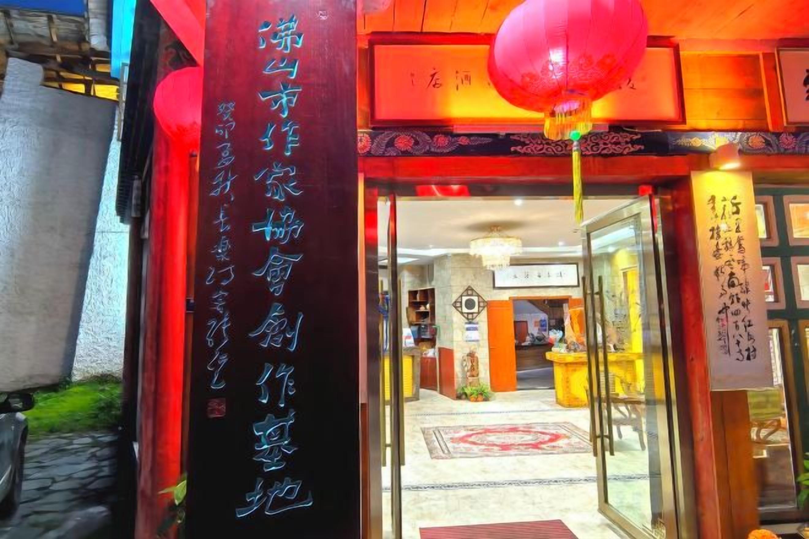 Uma entrada tradicional japonesa com um balão vermelho, uma porta de madeira e uma placa com caracteres japoneses.
